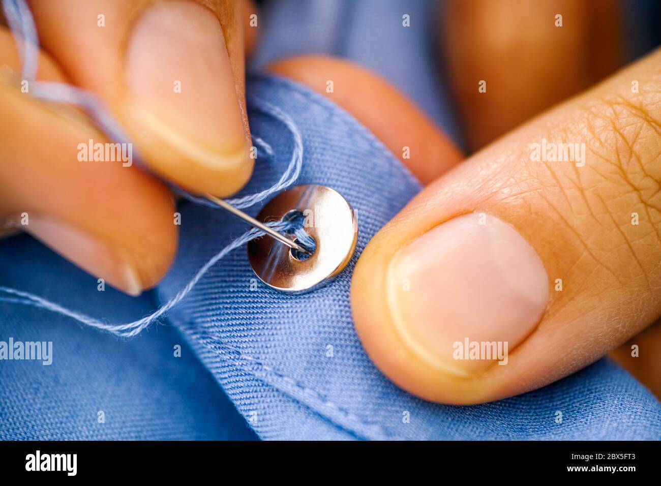 Close-up of woman fingers sewing a button Stock Photo - Alamy