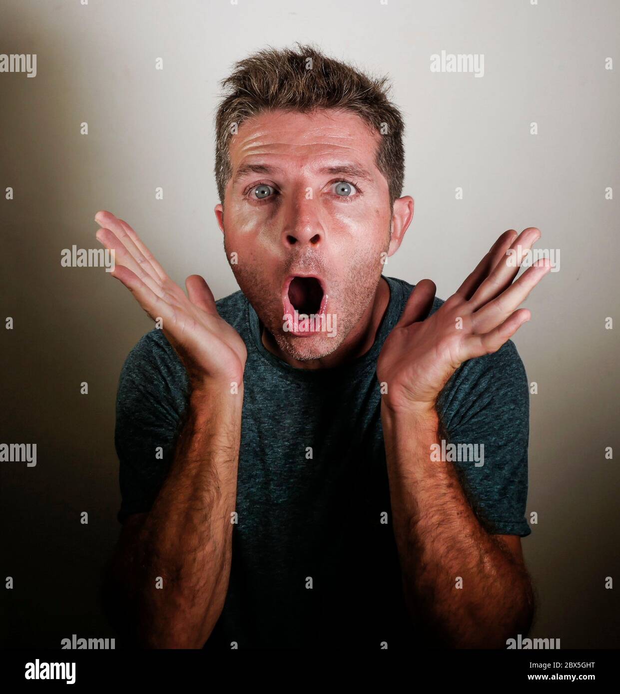 portrait of young attractive and surprised man gesturing in shock and ...