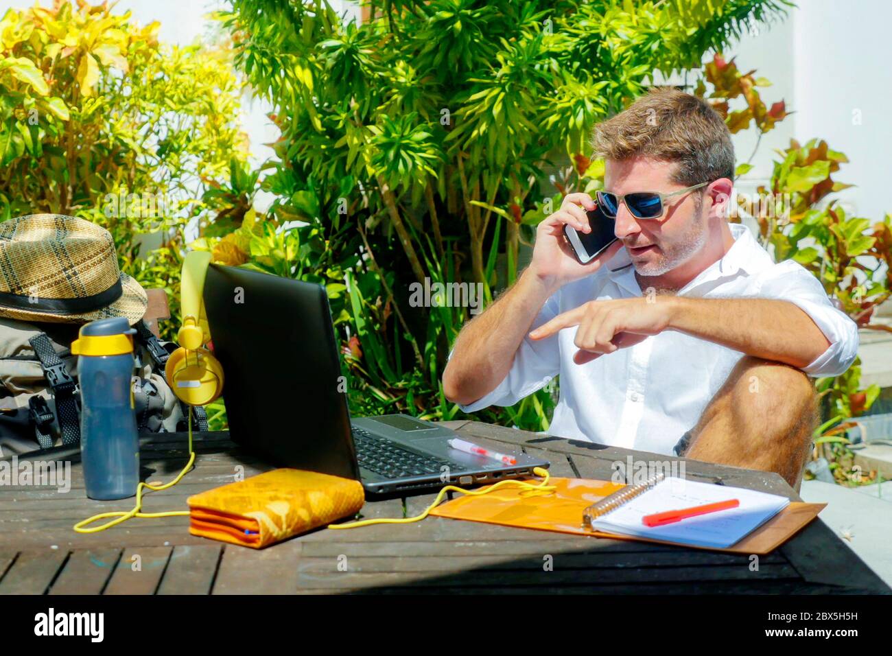 young attractive and happy digital nomad man working outdoors from ...