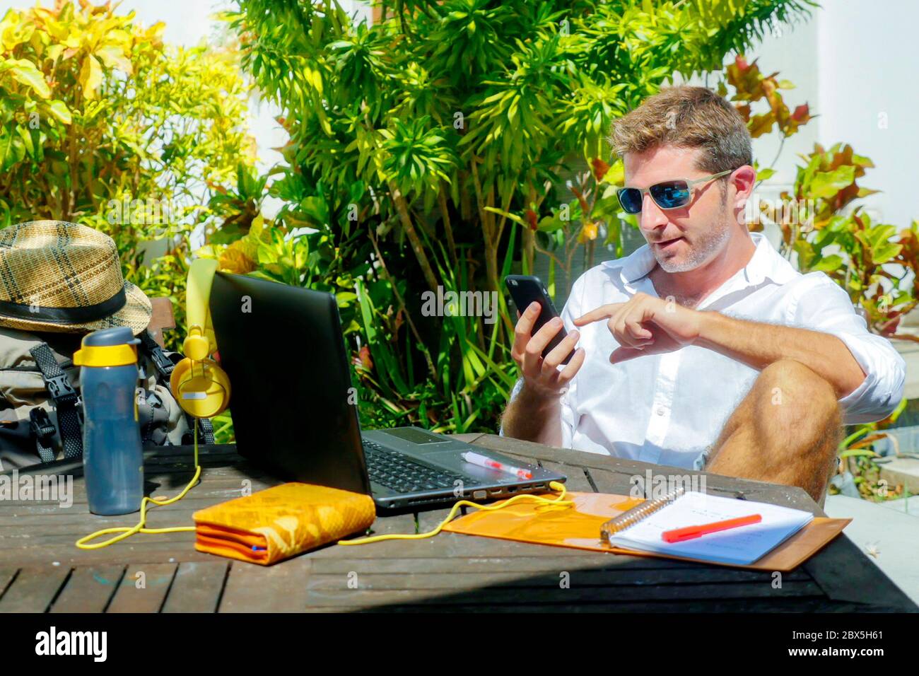 young attractive and happy digital nomad man working outdoors from ...