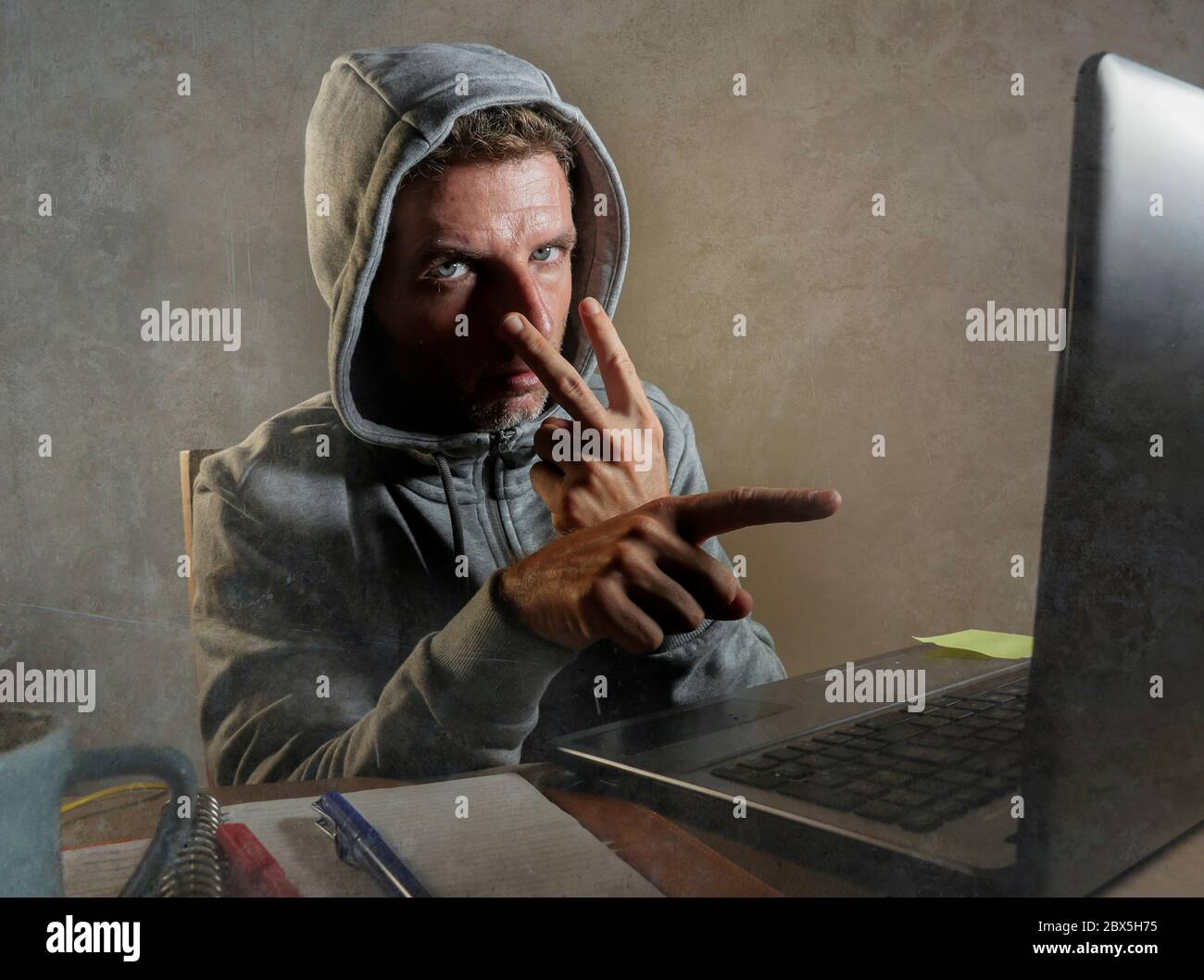 Dangerous Looking Hacker Man In Hoodie Hacking Internet Computer System Pointing His Eyes
