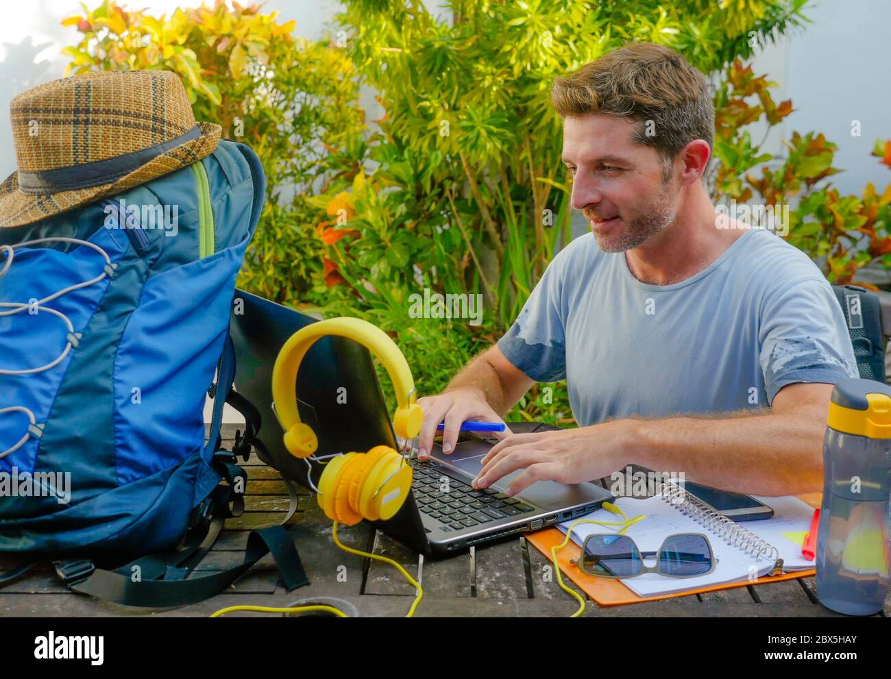 young attractive and happy digital nomad man working outdoors with ...