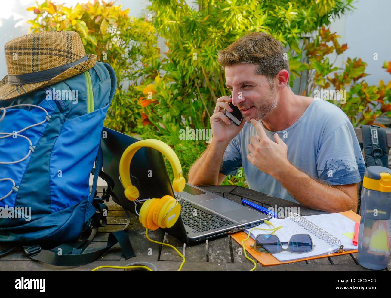 young attractive and happy digital nomad man working outdoors with ...
