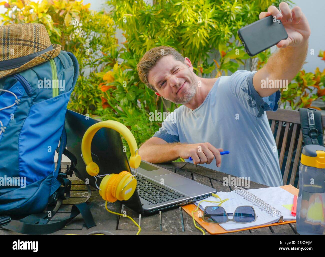 young attractive and happy digital nomad man working outdoors with ...