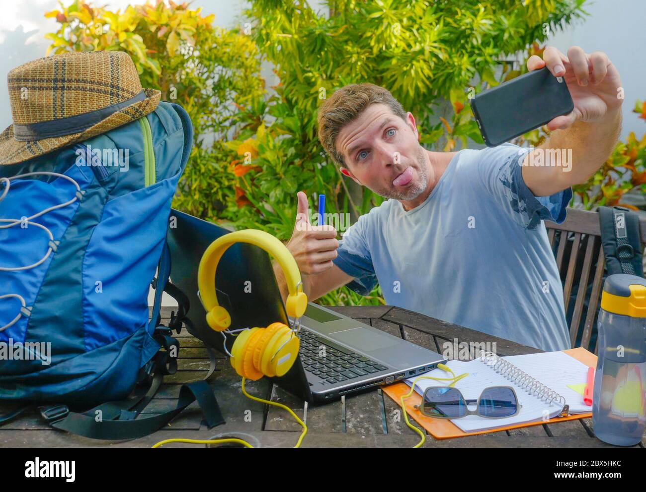 young attractive and happy digital nomad man working outdoors with ...