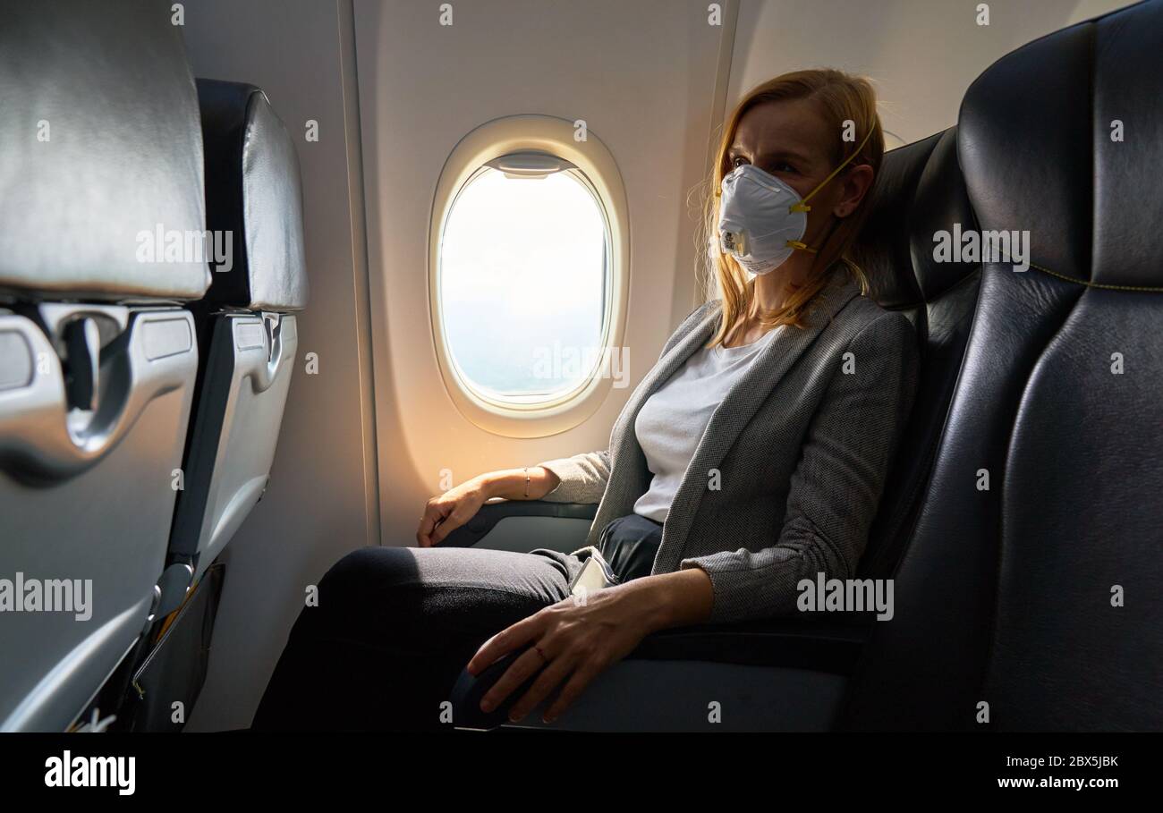 Woman wearing a face mask on a flight Stock Photo - Alamy
