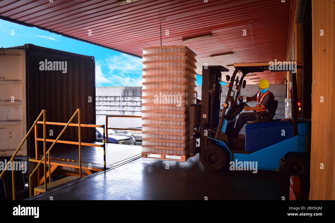 Container unstuffing, forklift carries pallets of cargo from container ...