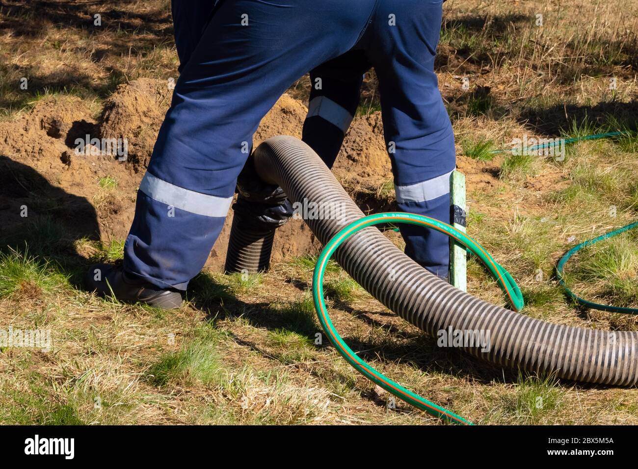 Man worker holding pipe, providing sewer cleaning service outdoor ...