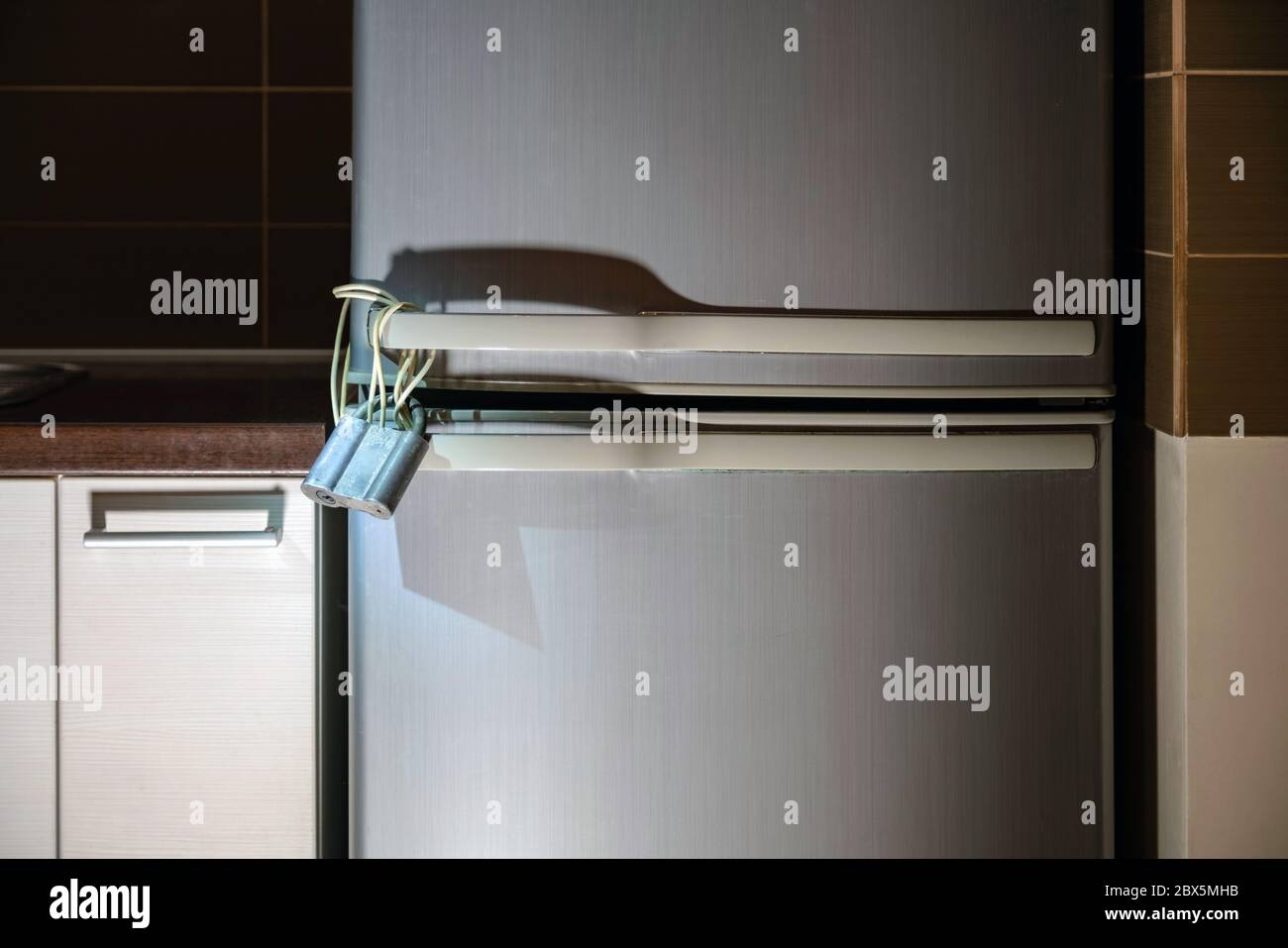 Lock on the fridge. Metal padlock hanging on the refrigerator. Concept ...