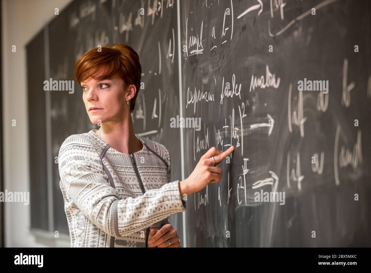 Teacher and action, presenting new curriculum to pupils on blackboard ...