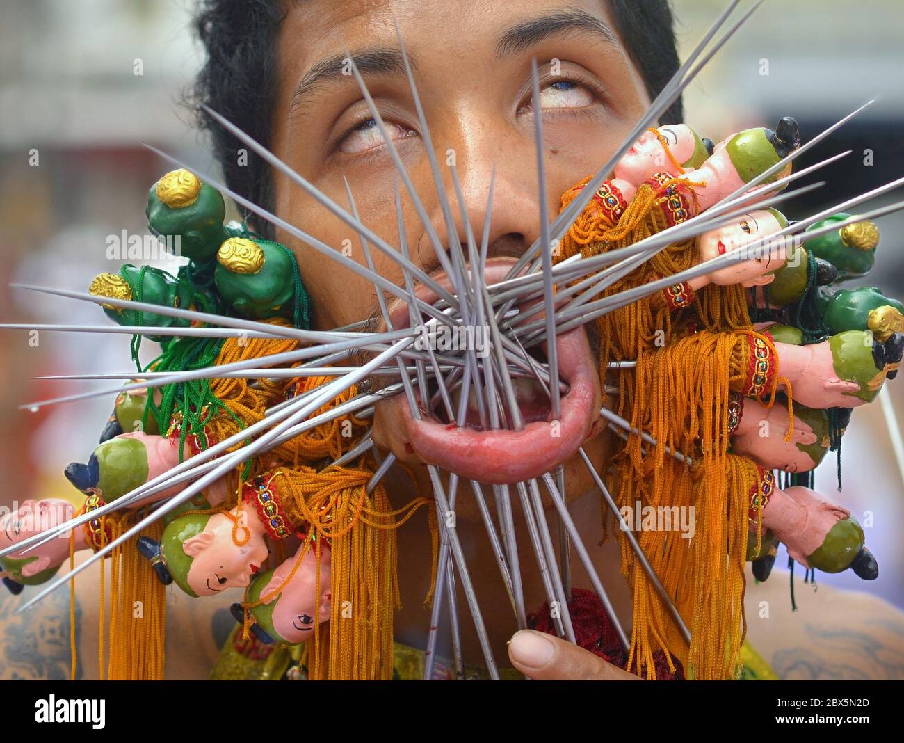 Entranced Thai Chinese Taoist devotee pierces his cheeks and lips with ...