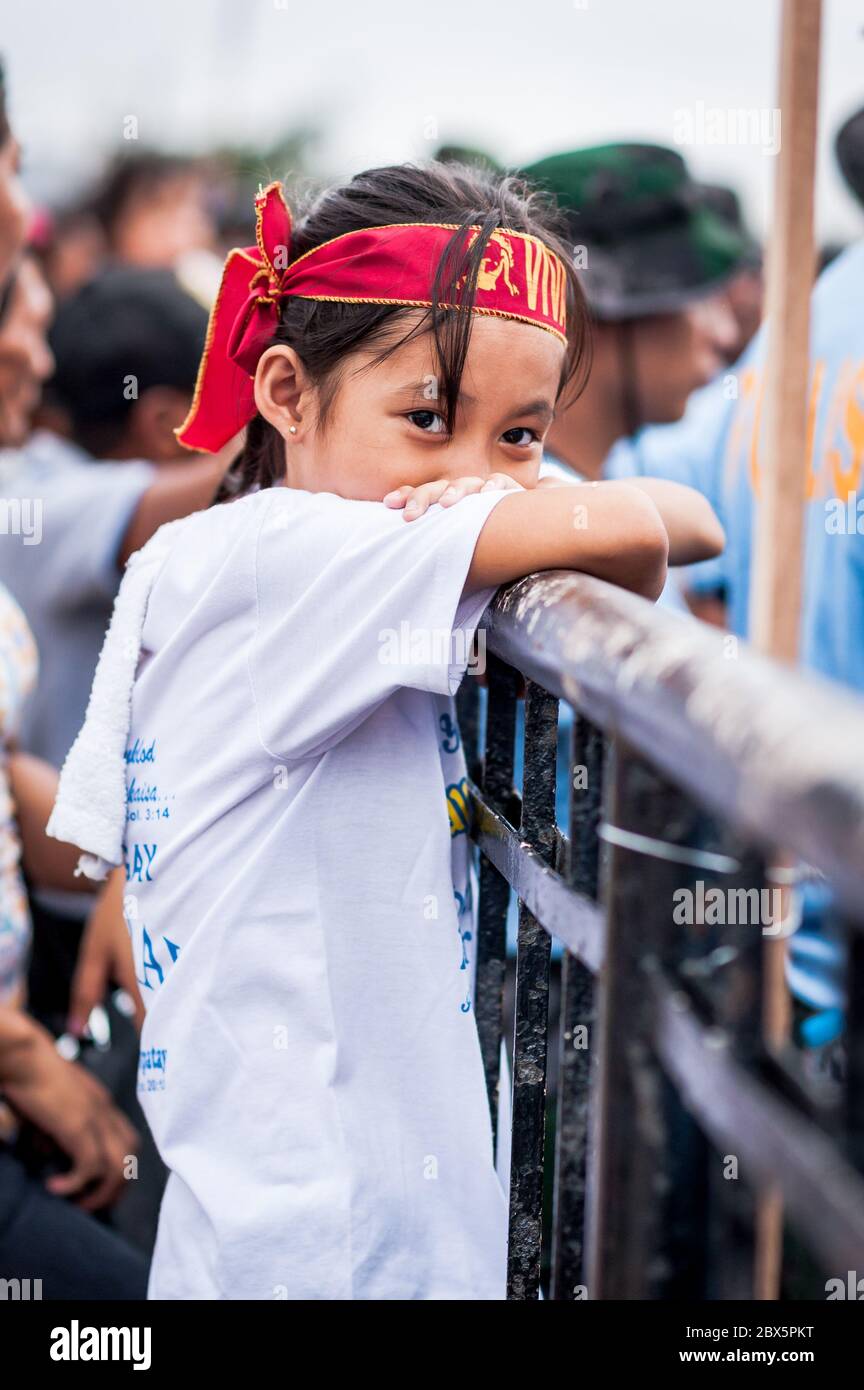 A beautiful Filipino girl watches the religious parade and celebrations ...