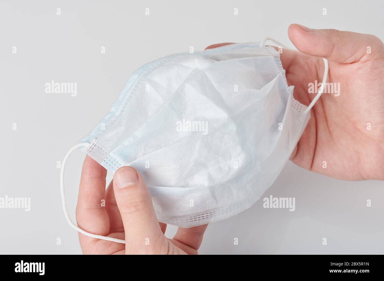 Face mask in hand close up view isolated on studio white background ...