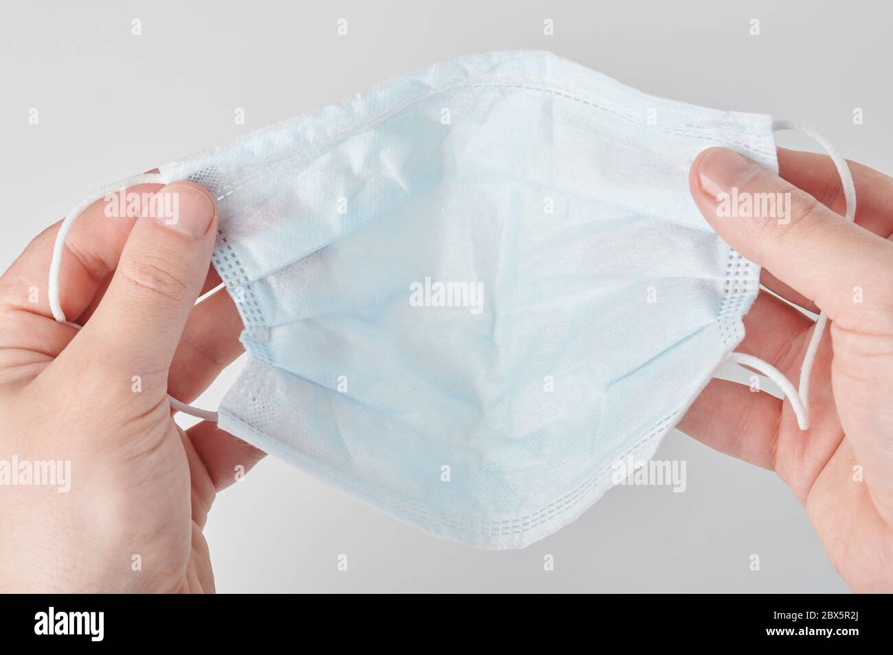 Hands hold face mask try to wear isolated on white background Stock ...