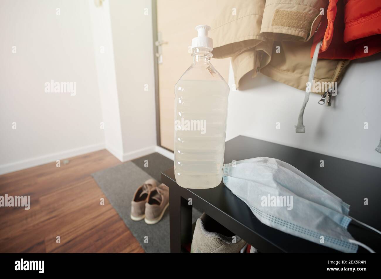 Sanitizer and face mask on bench in front door background Stock Photo ...