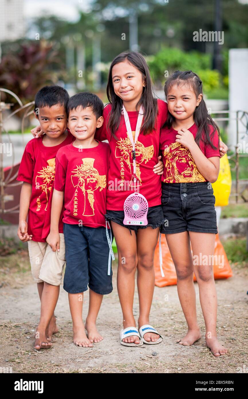 A group of beautiful filipino children, best friends or family embrace ...