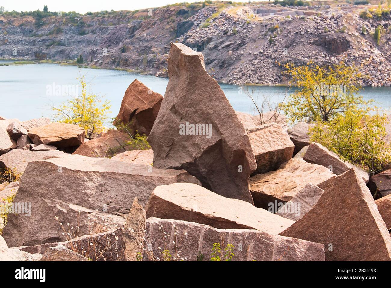 Old granite quarry with water. Large raw pieces of stone Stock Photo ...