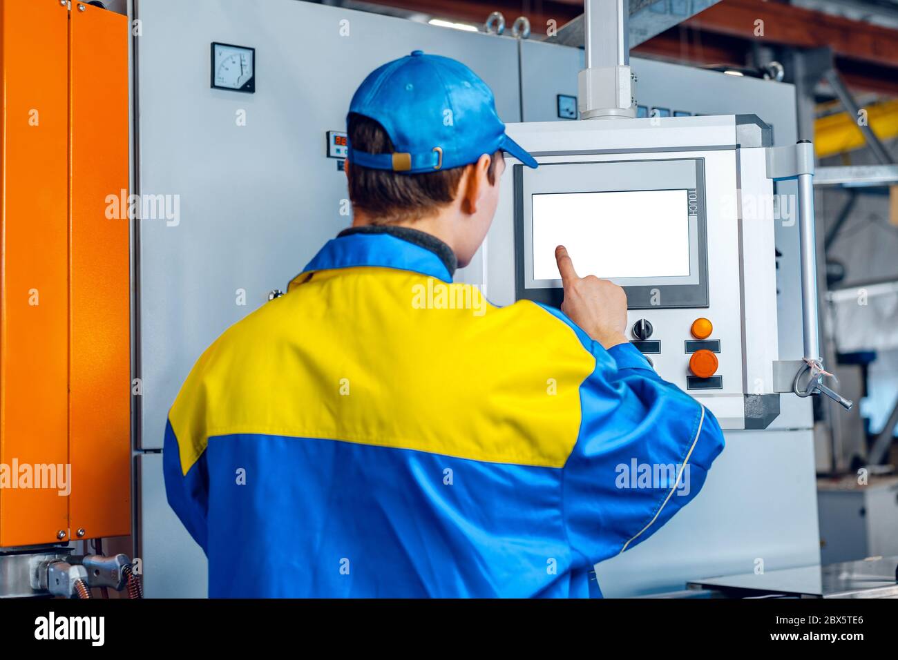 Man worker in manufacturing plant at cable factory machine control ...