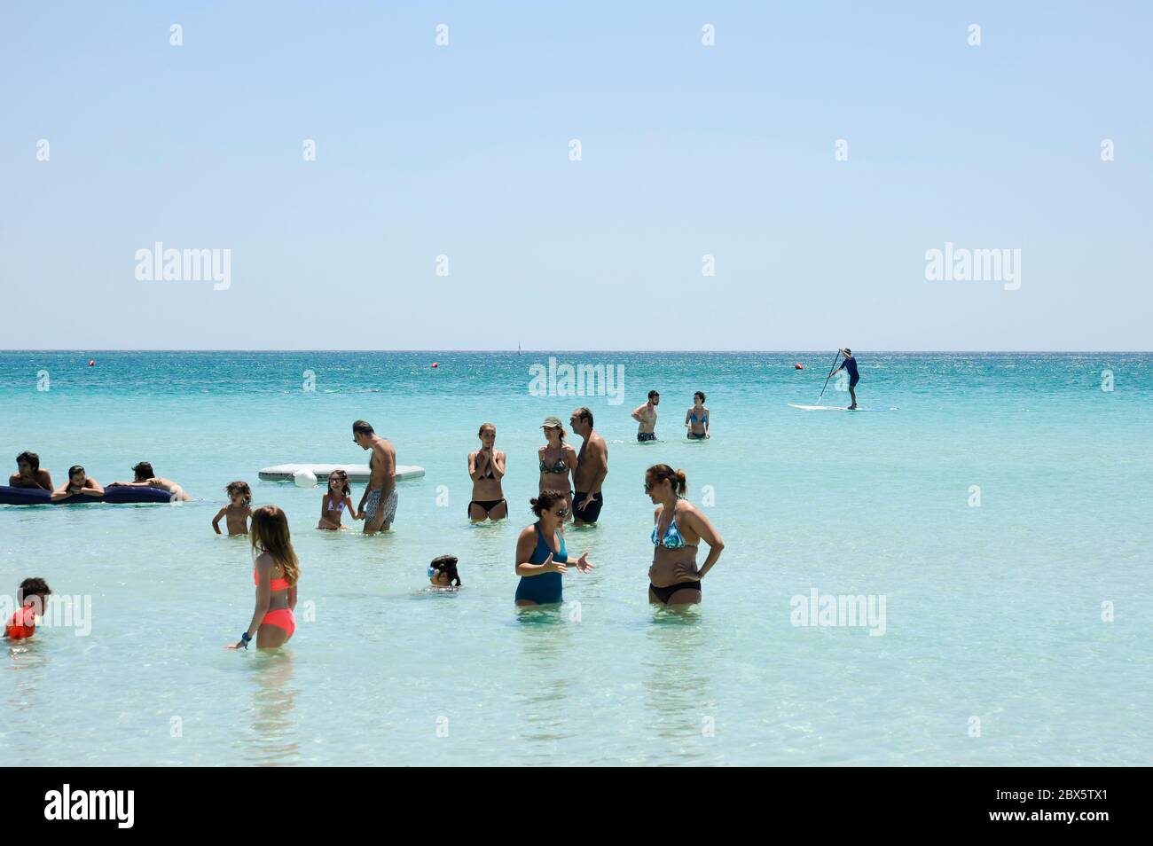 Bathers having fun and swim in the clear transparent waters of the sea ...