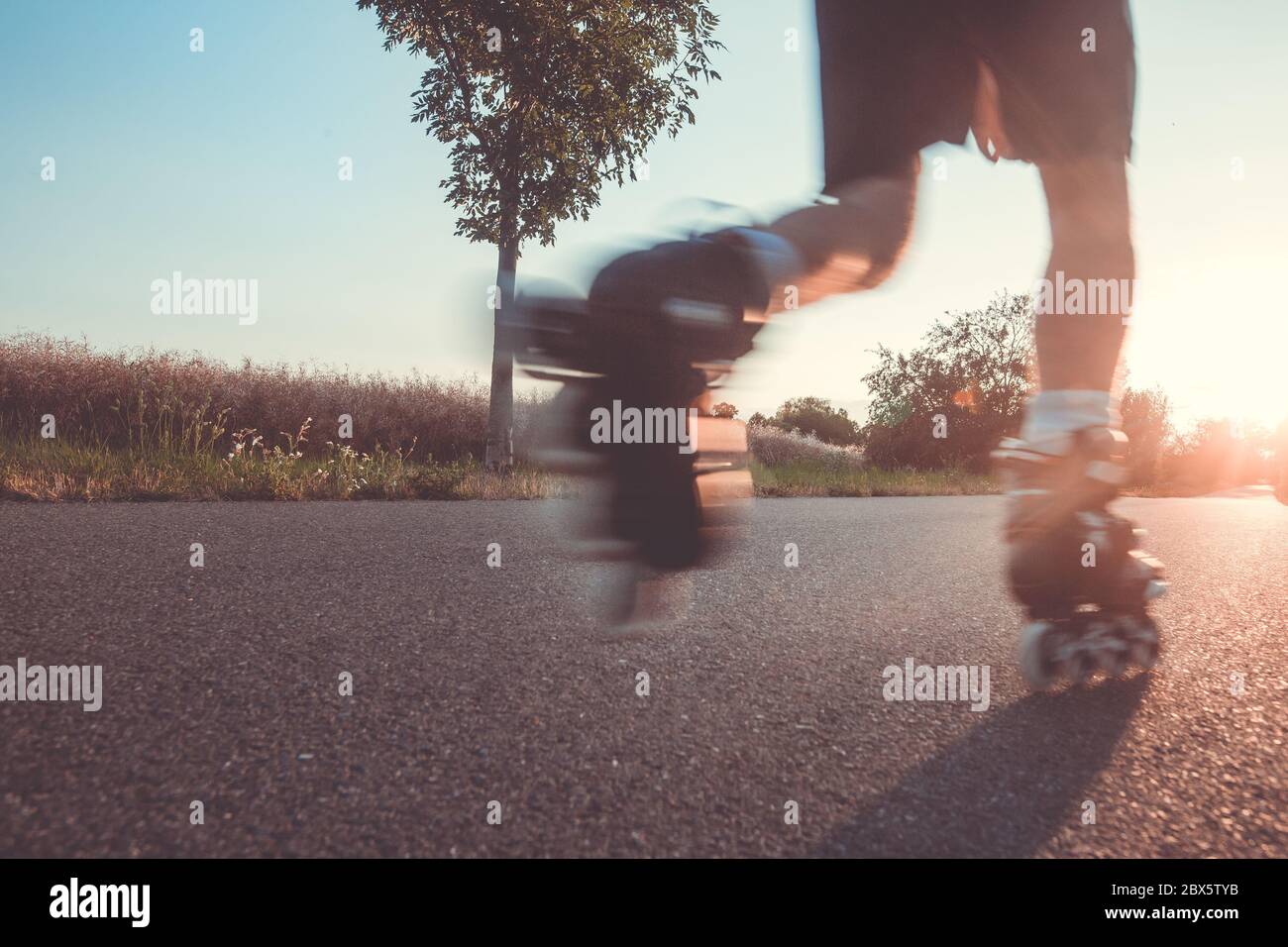 Young man enjoying roller skating on the bicycle path during lovely ...