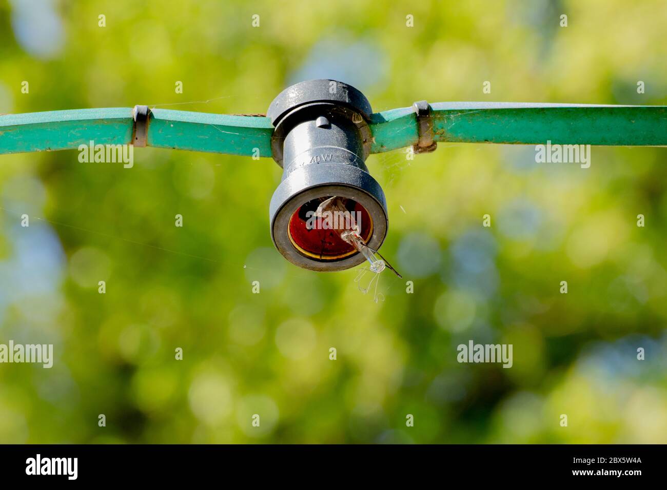 Close up of a dirty old broken light bulb hanging on a light chain in a ...