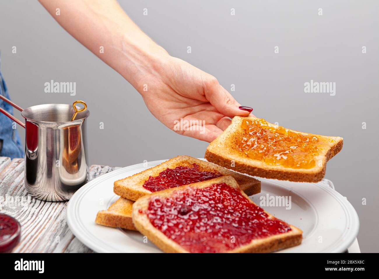 Female hands preparing toasts with fruit jam Stock Photo - Alamy