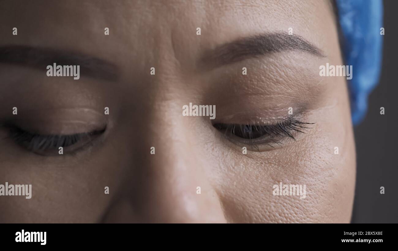 Tired doctor eyes. Beautiful eyes of a female health worker looking ...