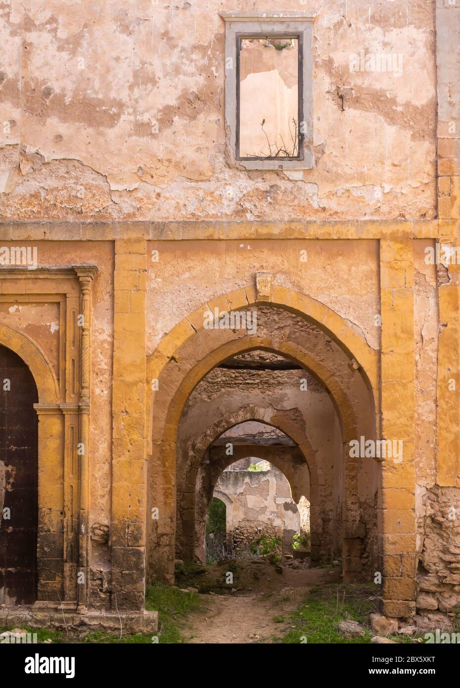 Abandoned old ruined building. Gate with an arc without door. Ruined ...