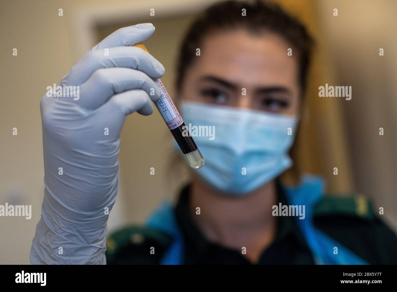Paramedic Jess Baddams holds a blood sample, during a coronavirus ...