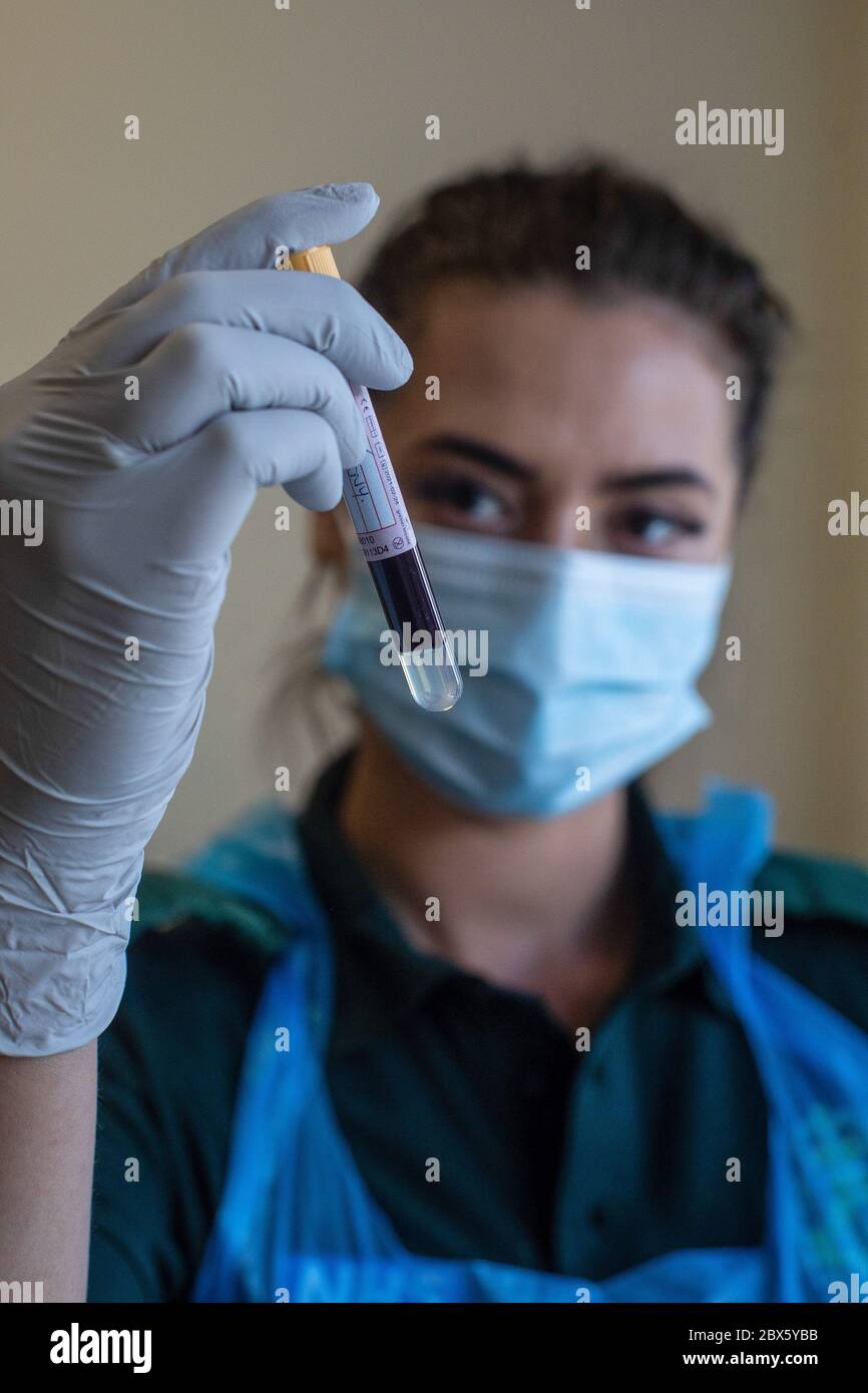 Paramedic Jess Baddams holds a blood sample, during a coronavirus ...