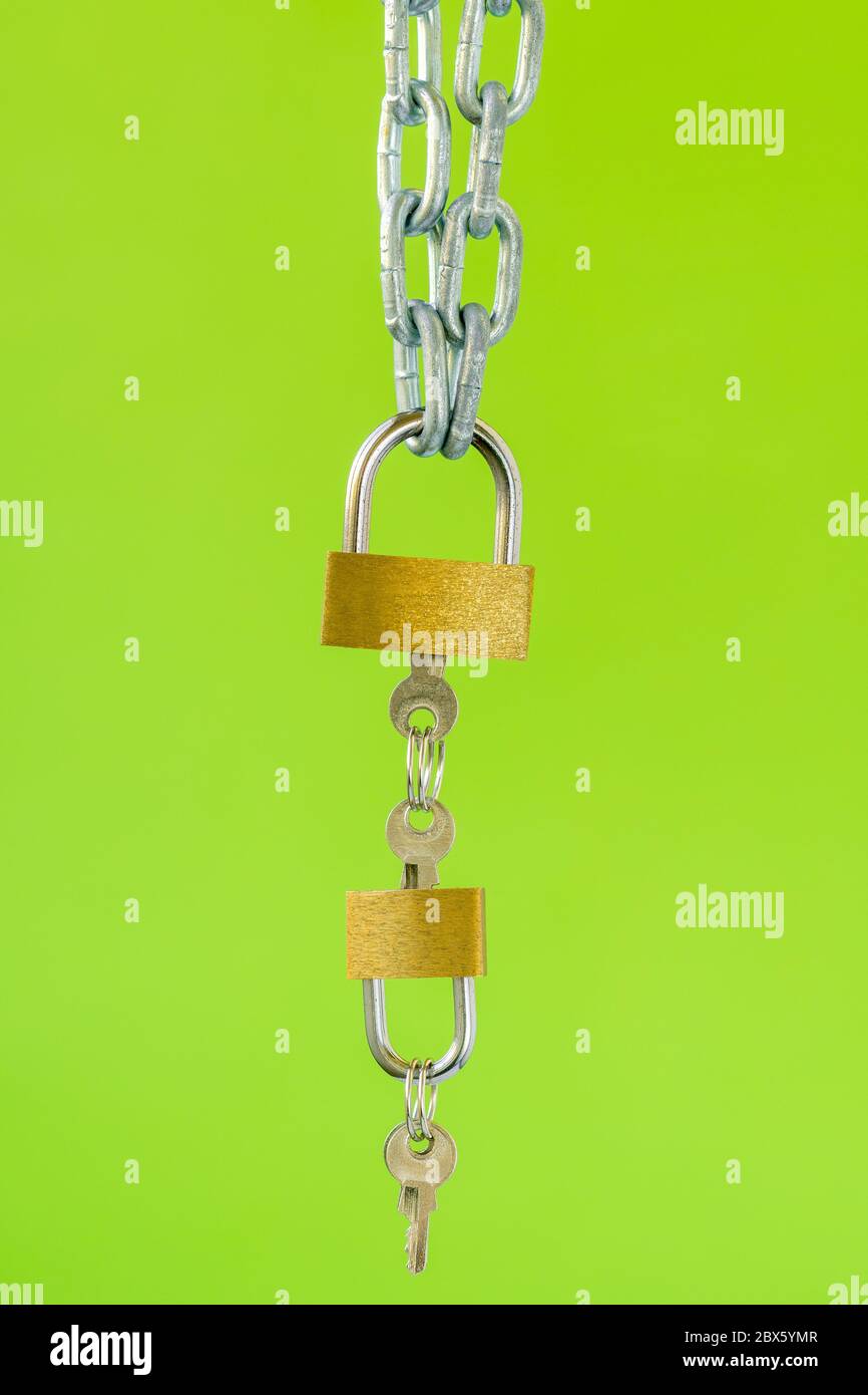 Gold padlocks with keys hanging on the metal chain Stock Photo - Alamy