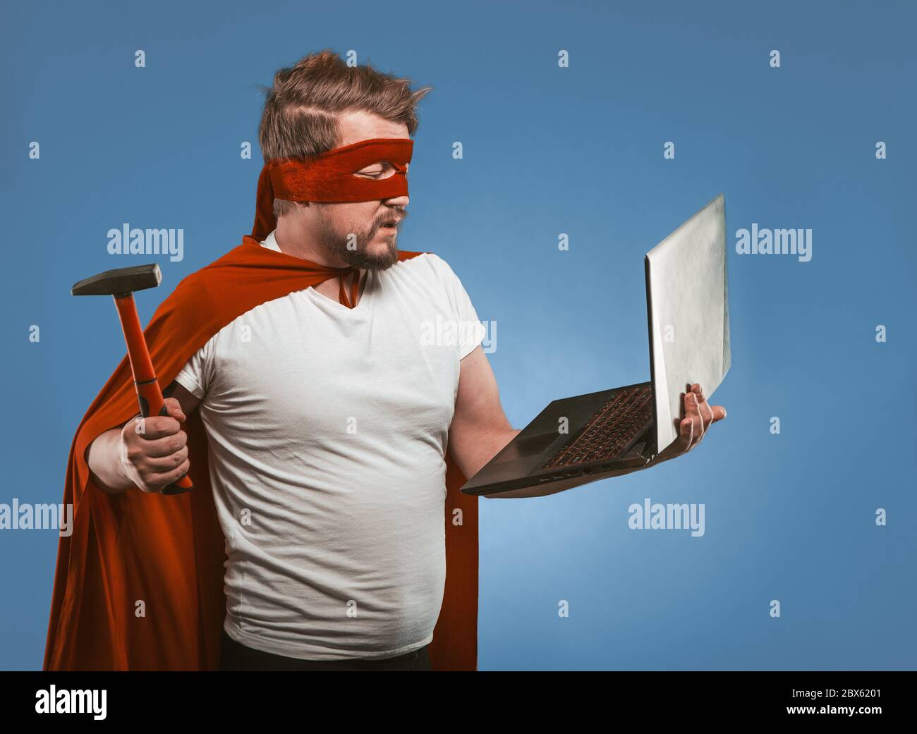 Super hero man going to smash or repair laptop computer with hammer ...