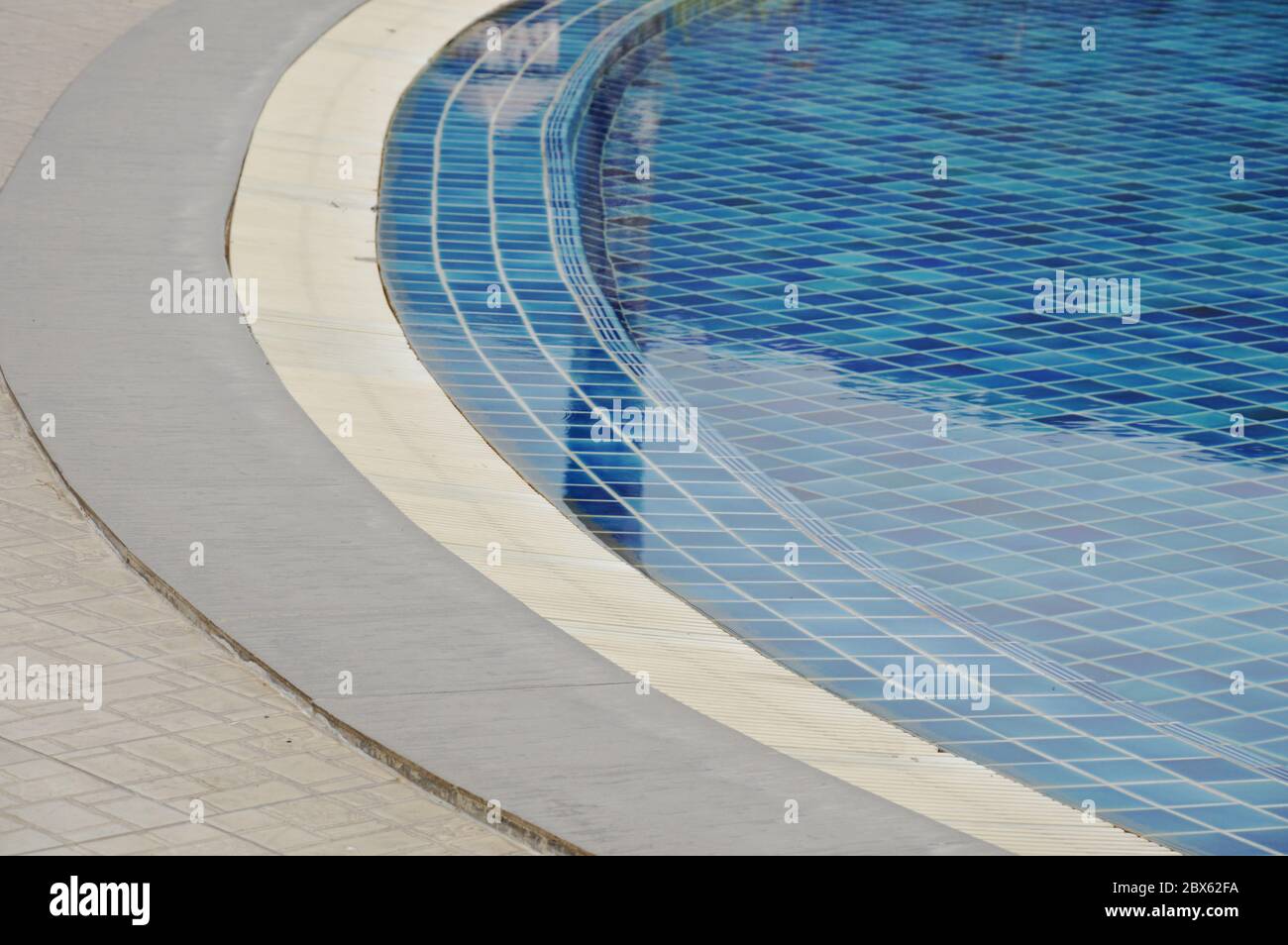 curve of blue tile swimming pool Stock Photo - Alamy