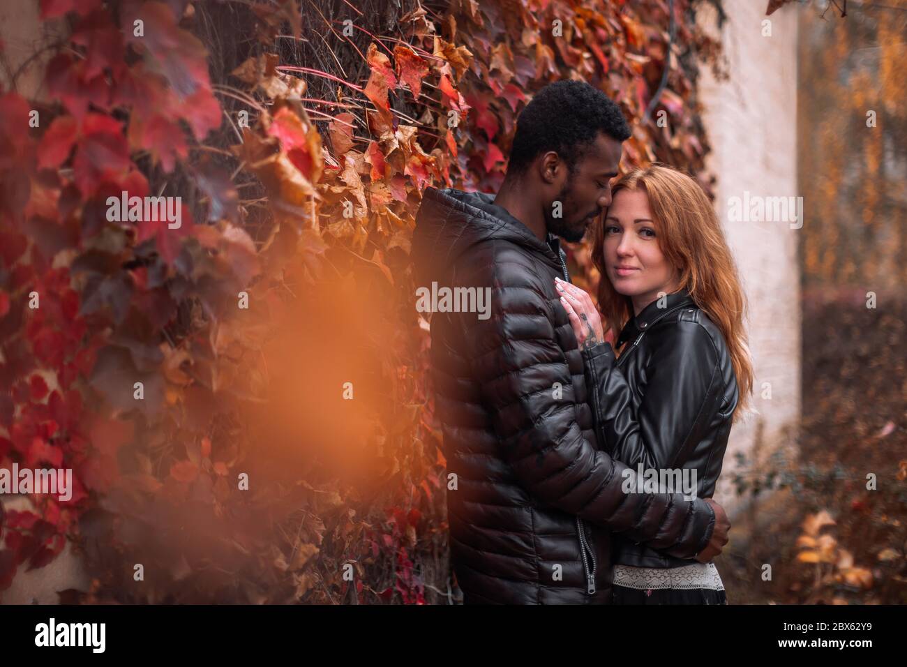 Interracial Couple Posing In Autumn Leaves Background Black Man And White Redhead Woman Stock