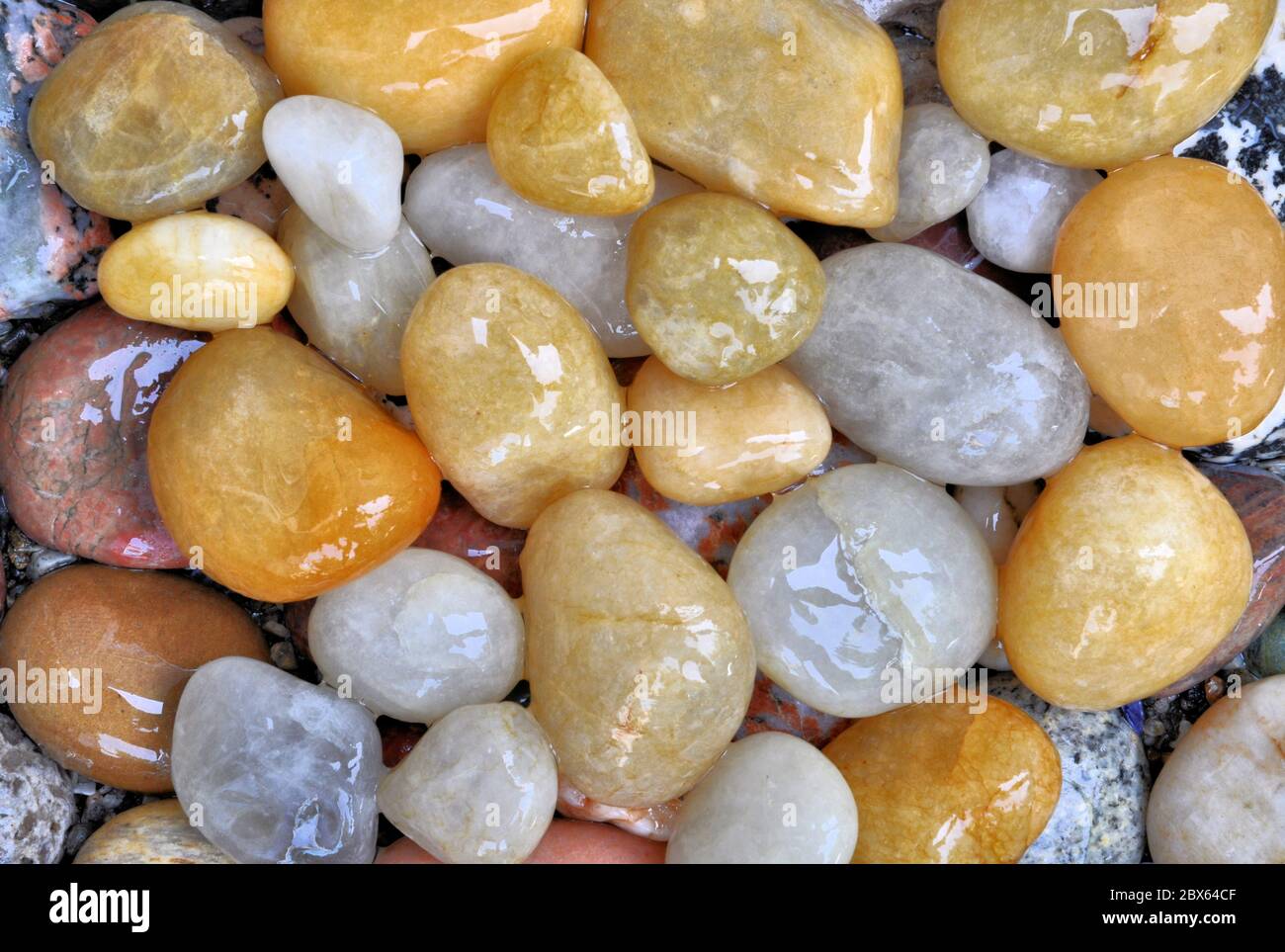 Closeup of smooth, rounded and colorful beach stones of different sizes ...