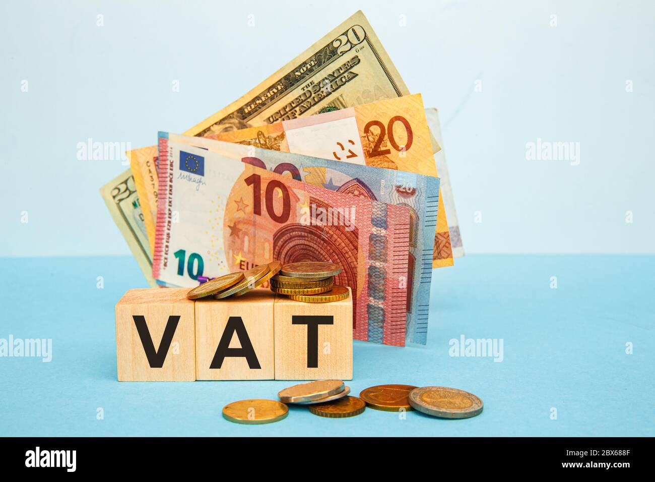 VAT word written on wood cubes on the background of various banknotes ...