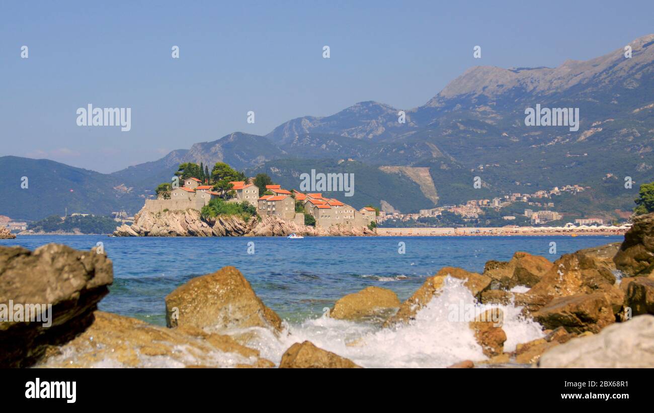Sveti Stefan island and waves of sea, Montenegro. Saint Stephen island ...