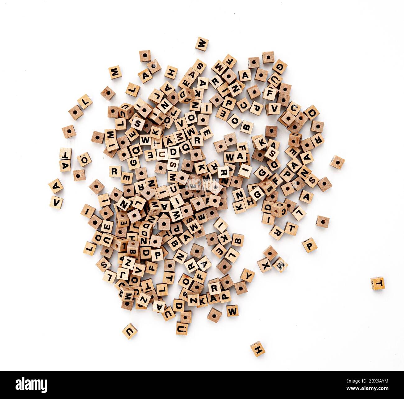 Small wooden cube beads with various letters scattered on white ...