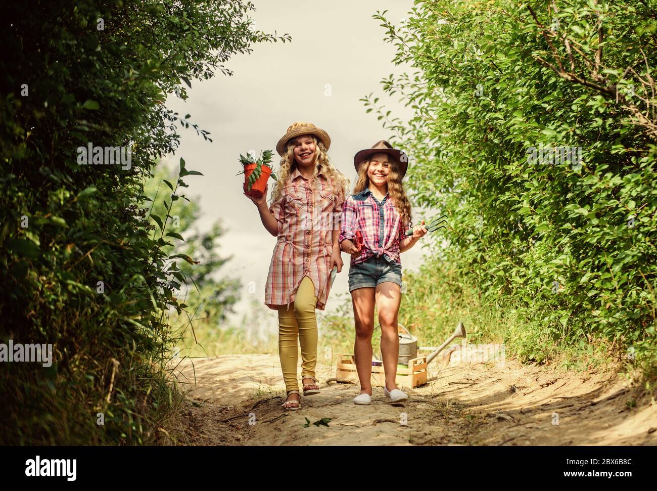 Girls with gardening tools. Agriculture concept. Adorable girls in hats ...
