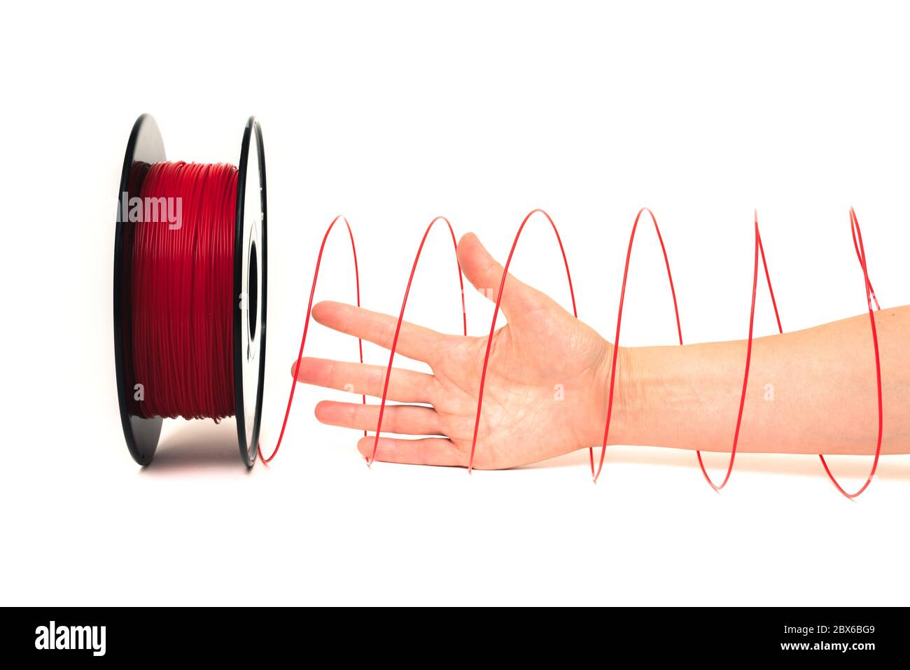 3D Printer Plastic Filament. Spool of red thermoplastic wire in hands ...
