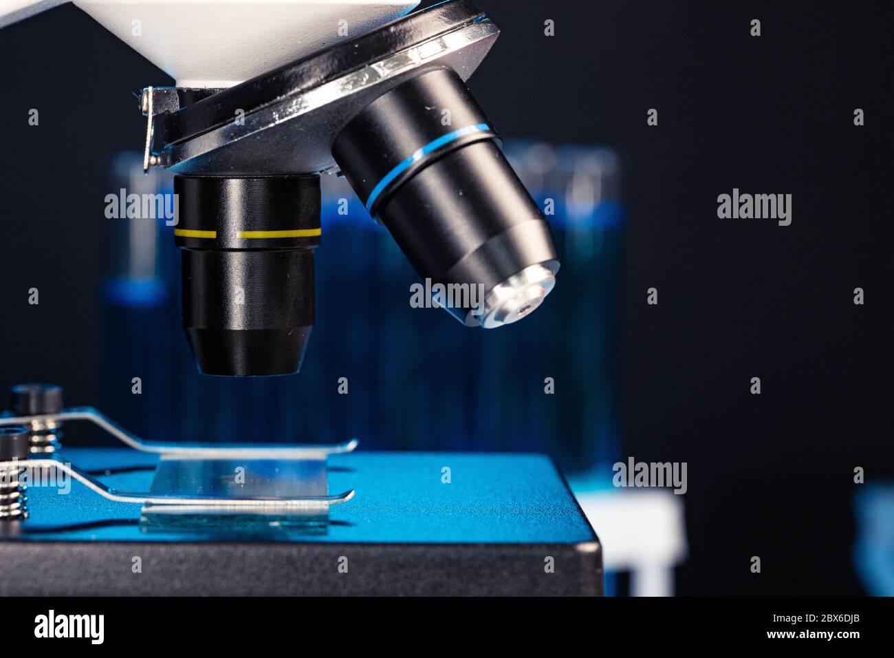 Microscope with lenses close up against dark background Stock Photo - Alamy