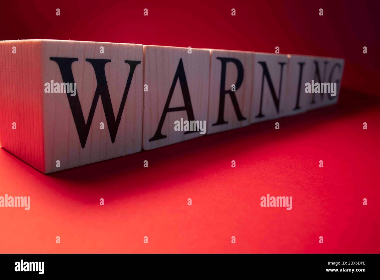 The word warning is written from wooden cubes Stock Photo - Alamy