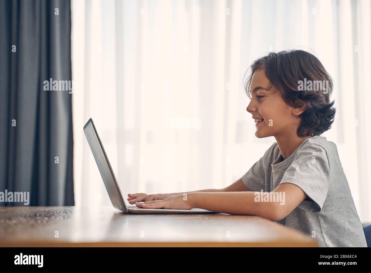 Smart little child using electronic device in room Stock Photo - Alamy
