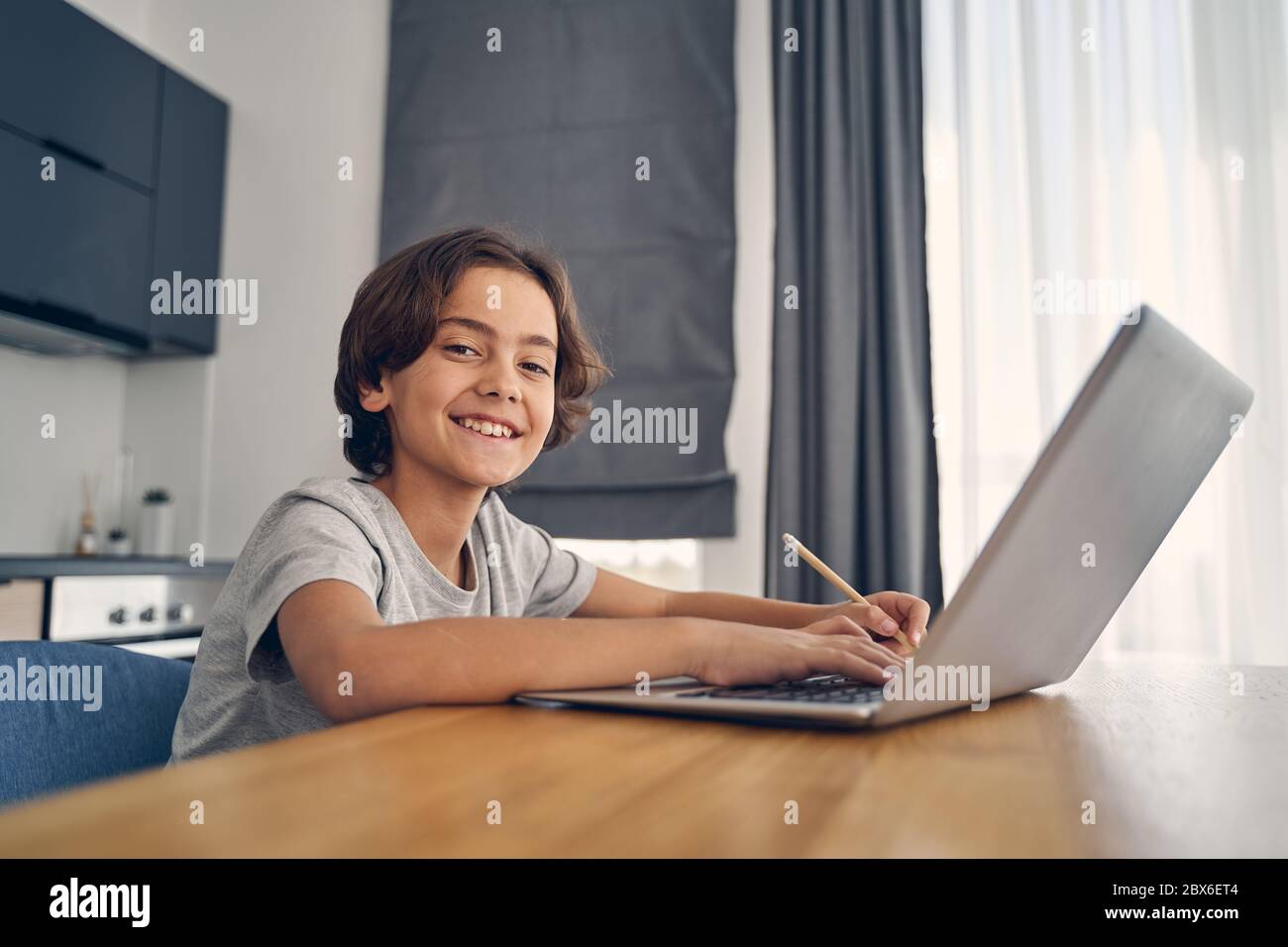 Happy little boy sitting and smiling nicely Stock Photo - Alamy