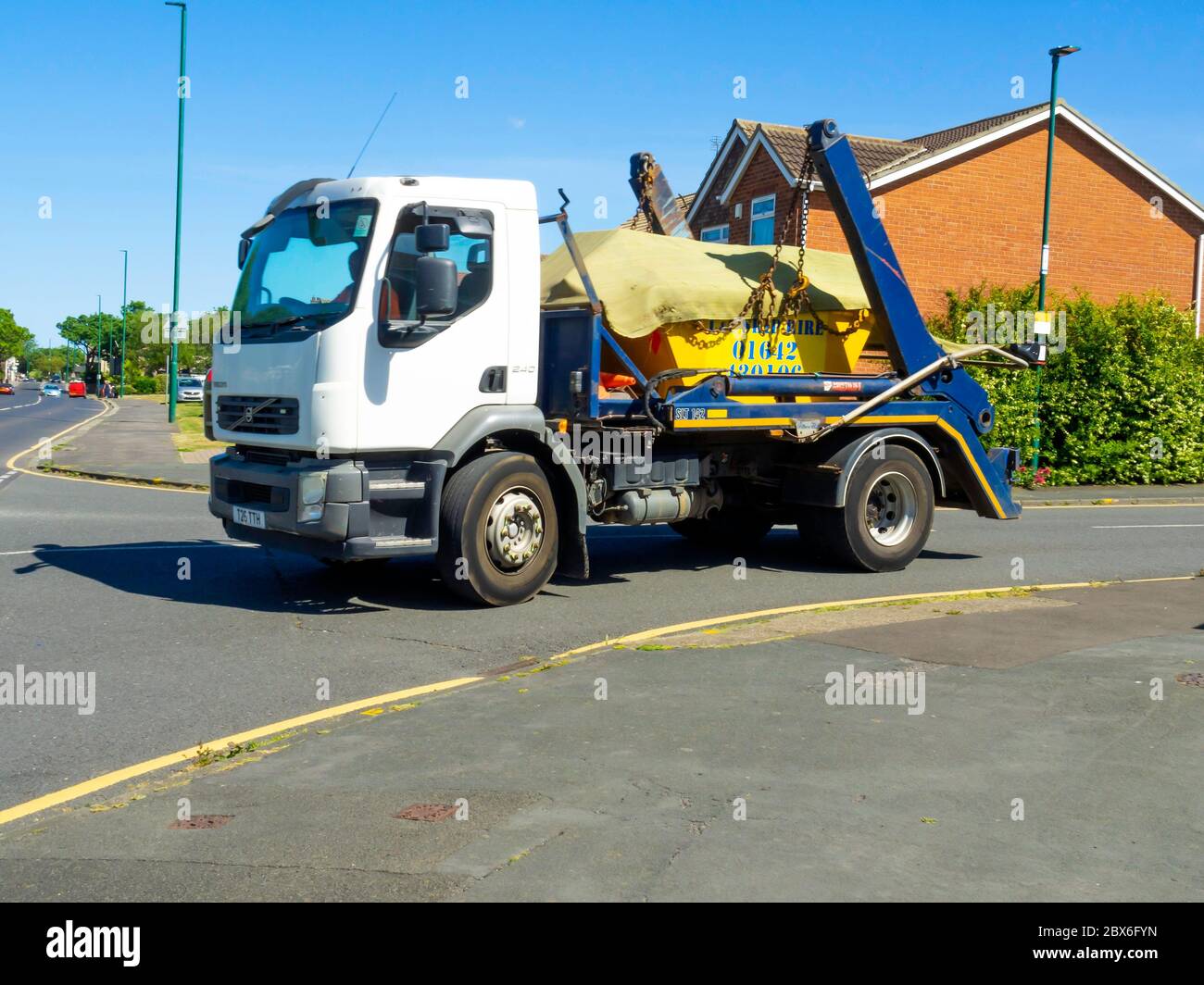 A waste skip picked up by a truck beside from residential in a North ...
