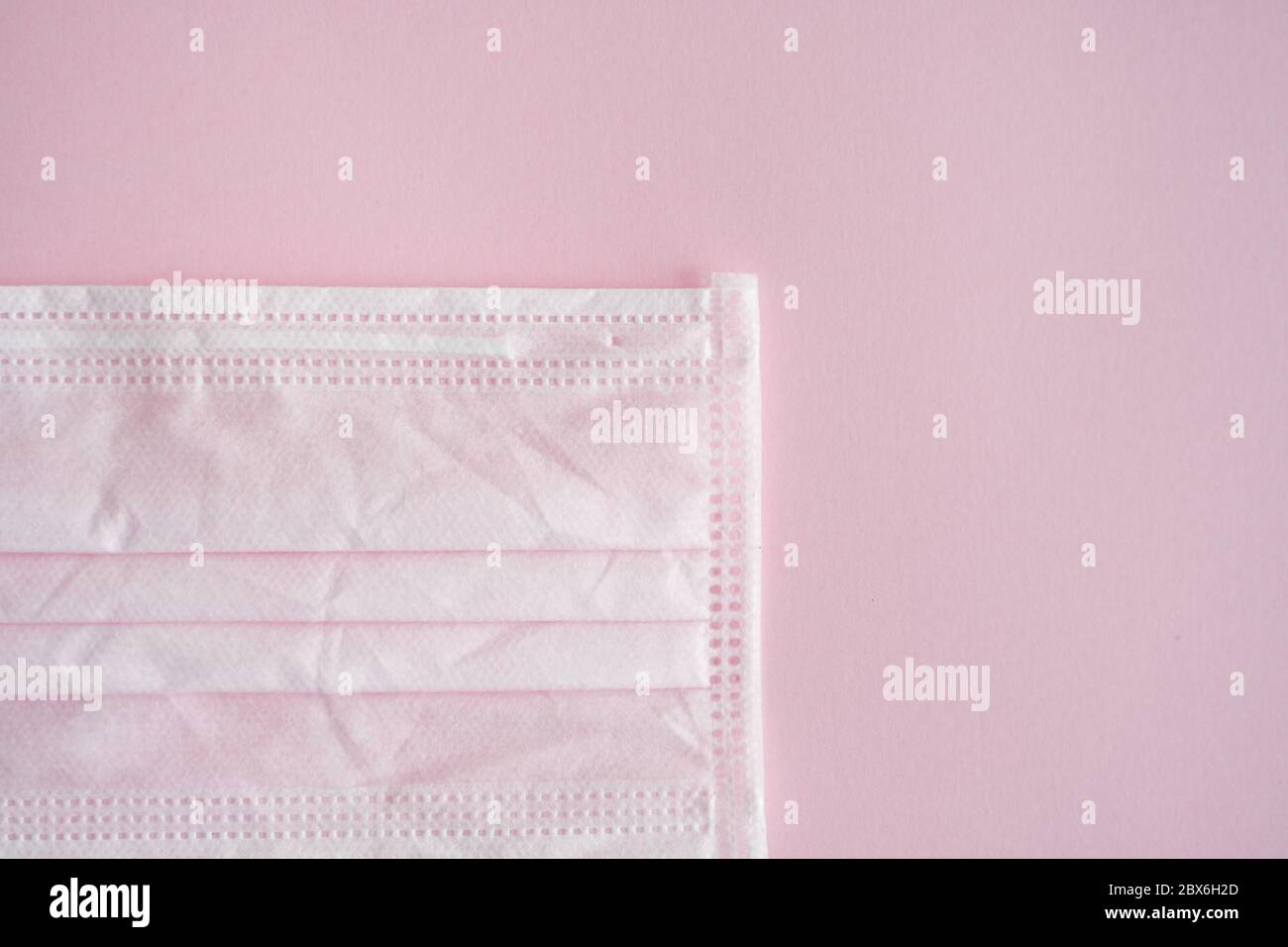 Used pink medical mask on a pink background. Disposable 3-ply medical ...