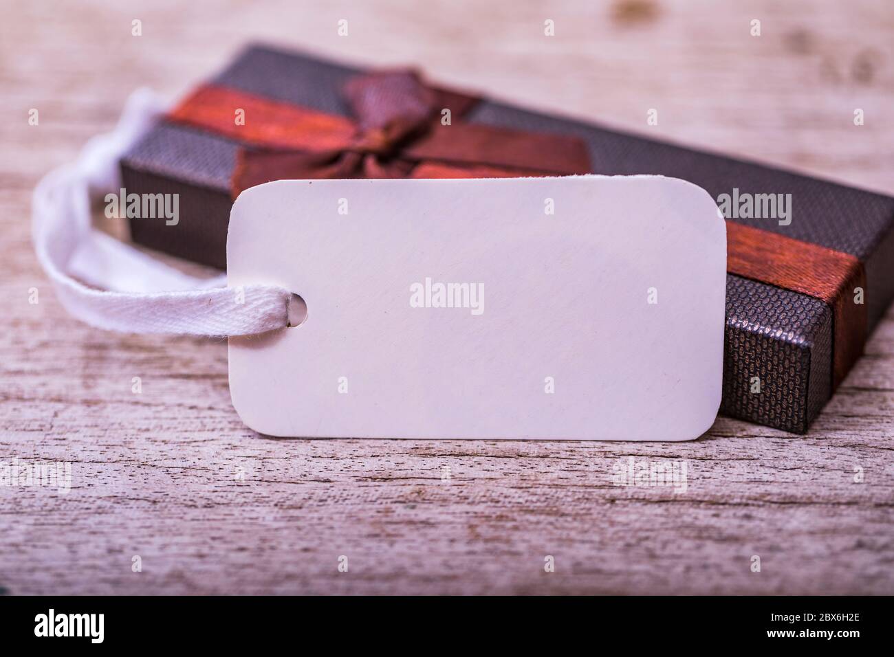 Vintage gift box or packag with blank gift tag on old wooden background ...