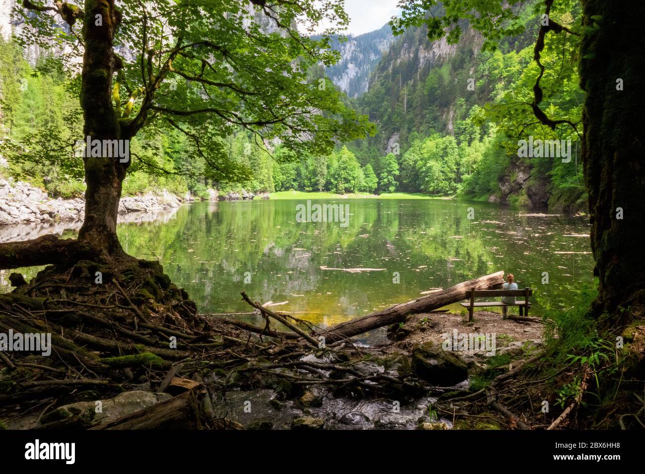 Woman sitting at the lakeshore of the legendary Lake Kammersee, Ausseer ...