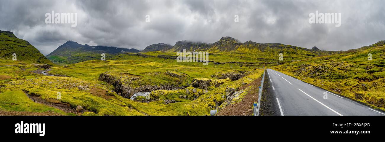 Panoramic view over lonely road through rough and greenish Icelandic ...