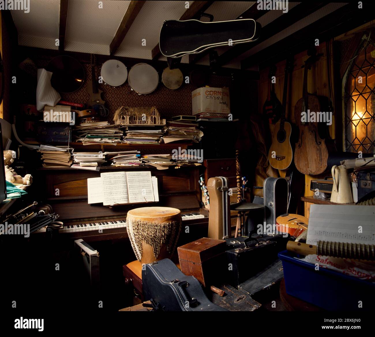 Small cluttered music room in old cottage Stock Photo - Alamy